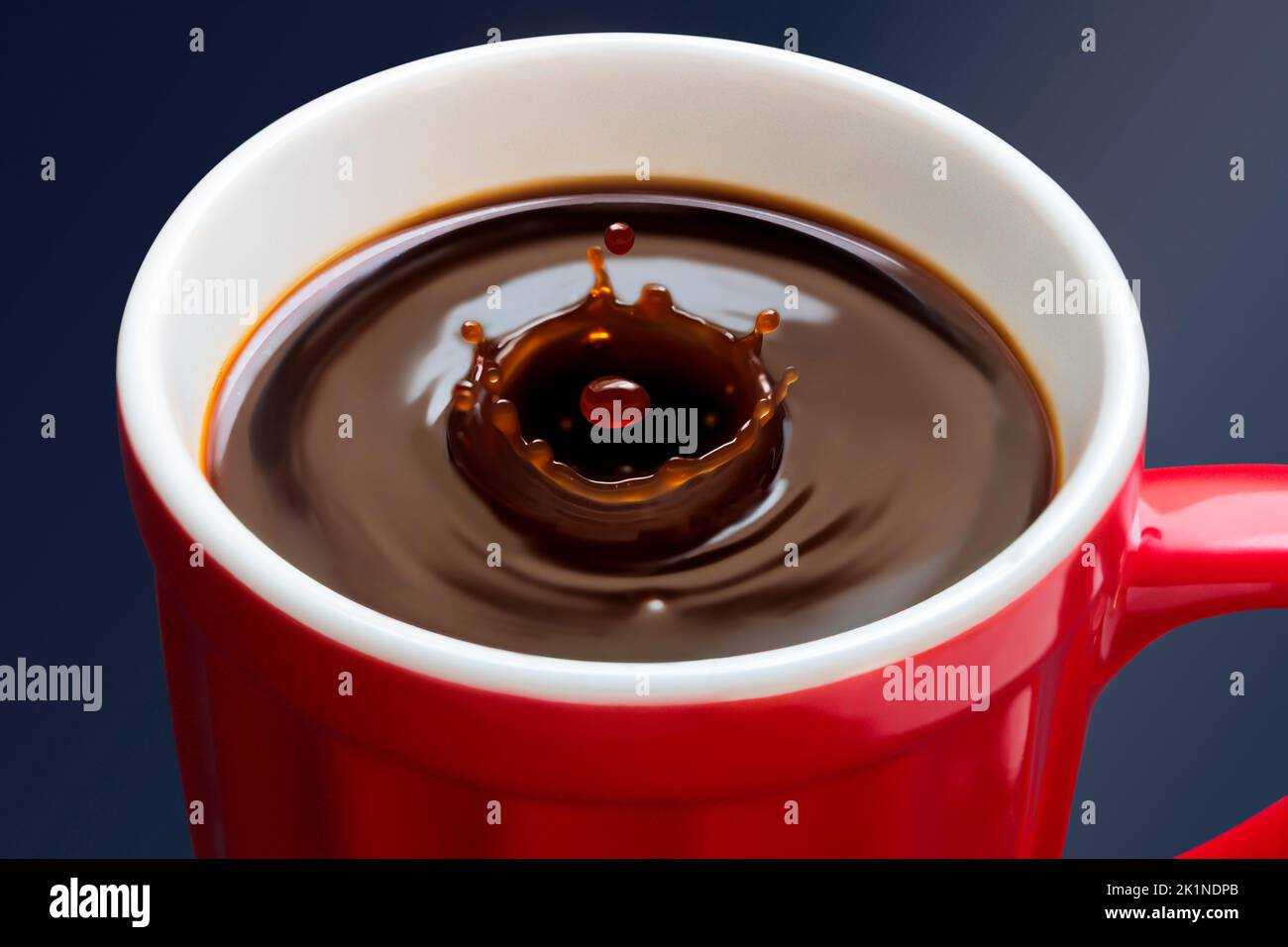 Drop of coffee falls into a red coffee cup. Close-up Stock Photo - Alamy