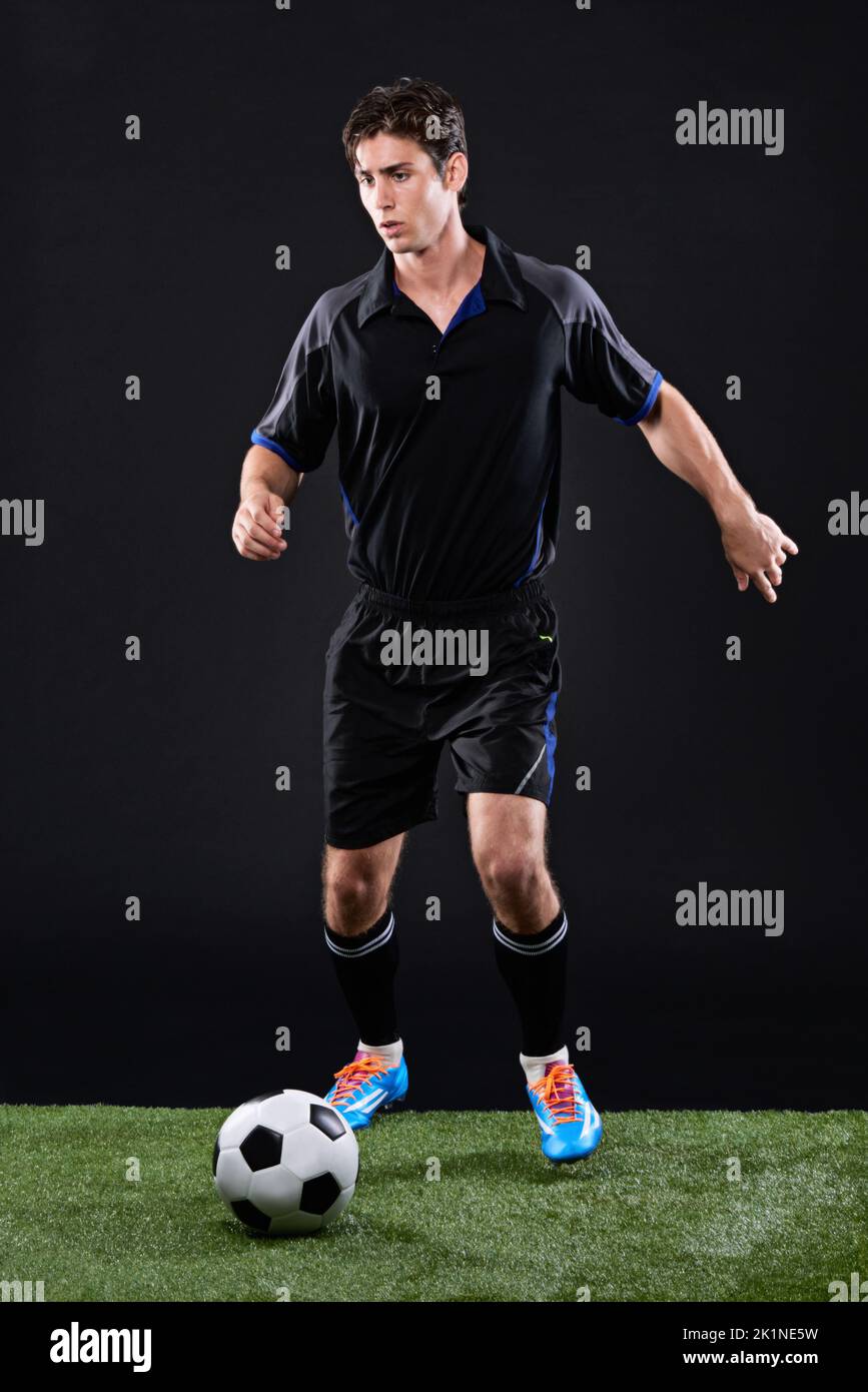 Whats life without goals. a handsome soccer player isolated on black ...