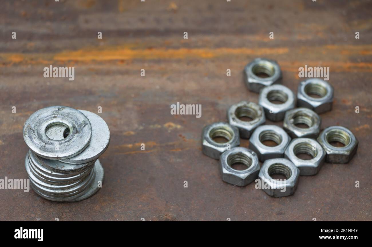 A few flat metal washers and Metal shine nuts in te background on a on ...