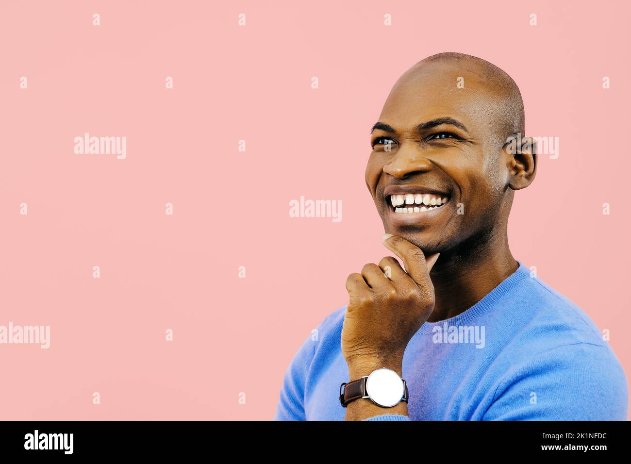 profile smiling man with hand on chin looking at copy space indoors ...