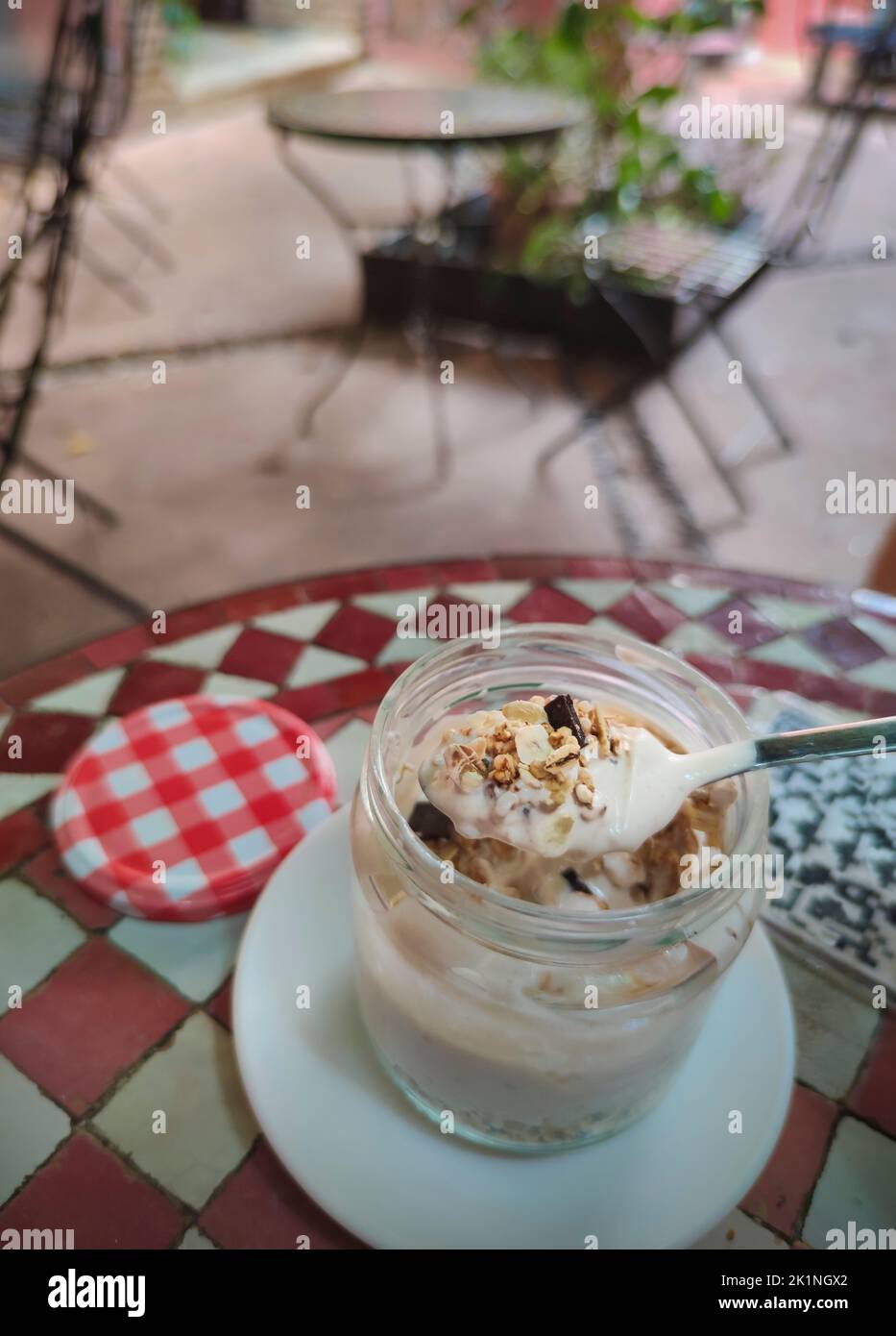 Spoonful of yogurt with muesli from glass jar. QR code sticker over ...