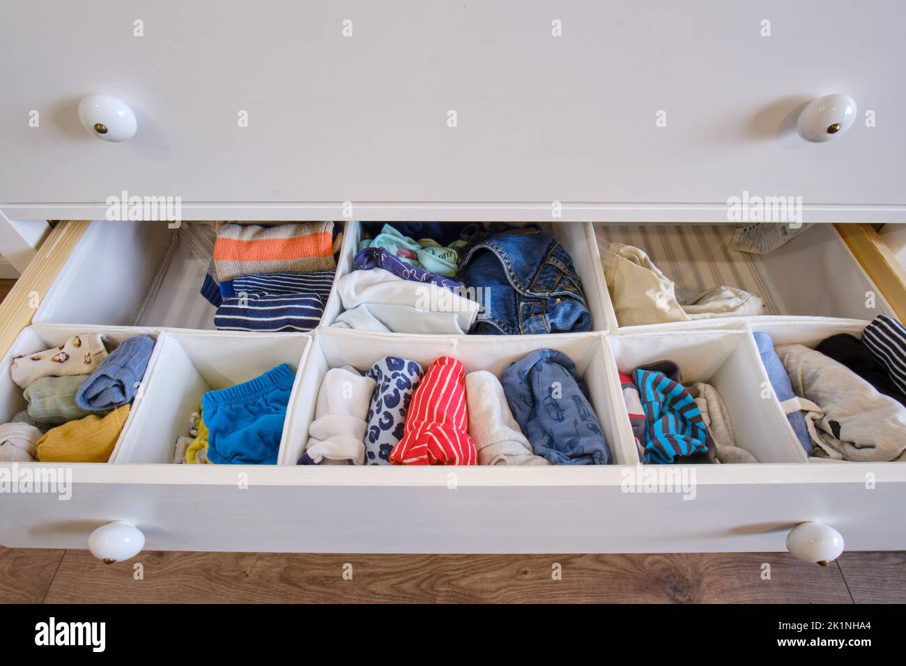 Storage of children s clothes in white chest of drawers, open closet ...