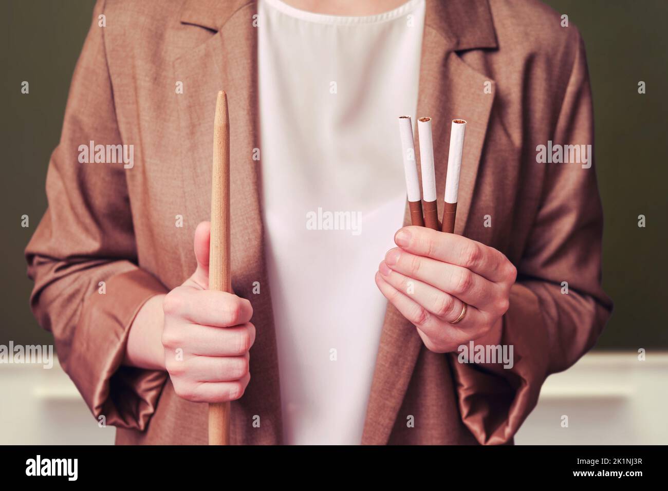 Woman teacher holding cigarettes on school blackboard in the classroom ...