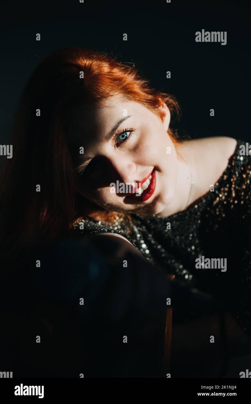 Portrait of redhead female singer woman in sparkly evening dress ...