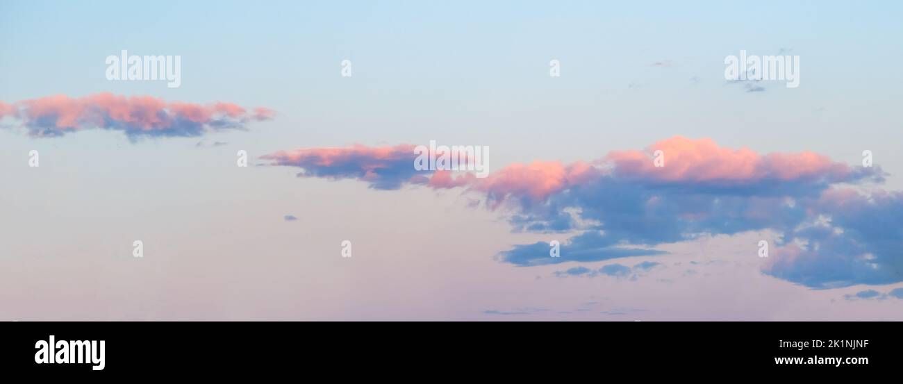 Blue sky with twilight clouds. The sun is setting over the horizon ...