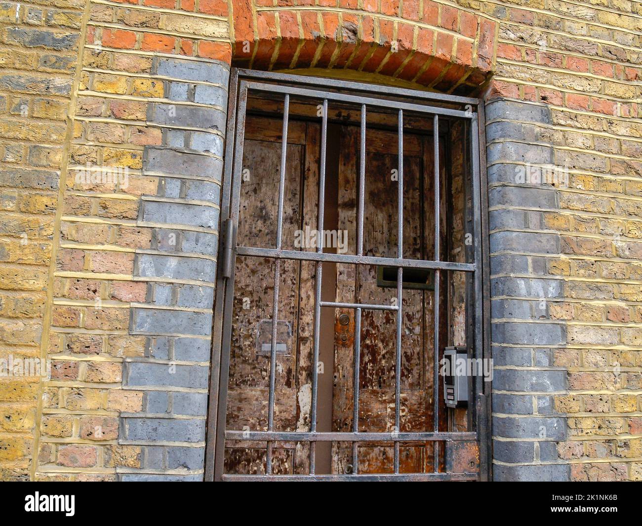 Old brick wall with locked iron security grille and lock Stock Photo ...