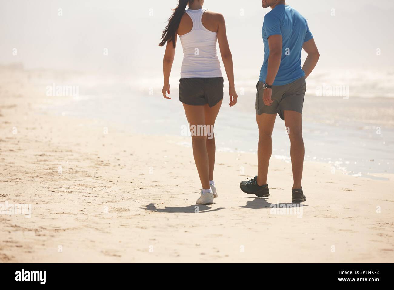 Were in it together. Rearview shot of a young couple walking on the ...