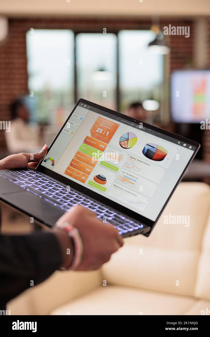 Man holding laptop with business charts in company office, management ...