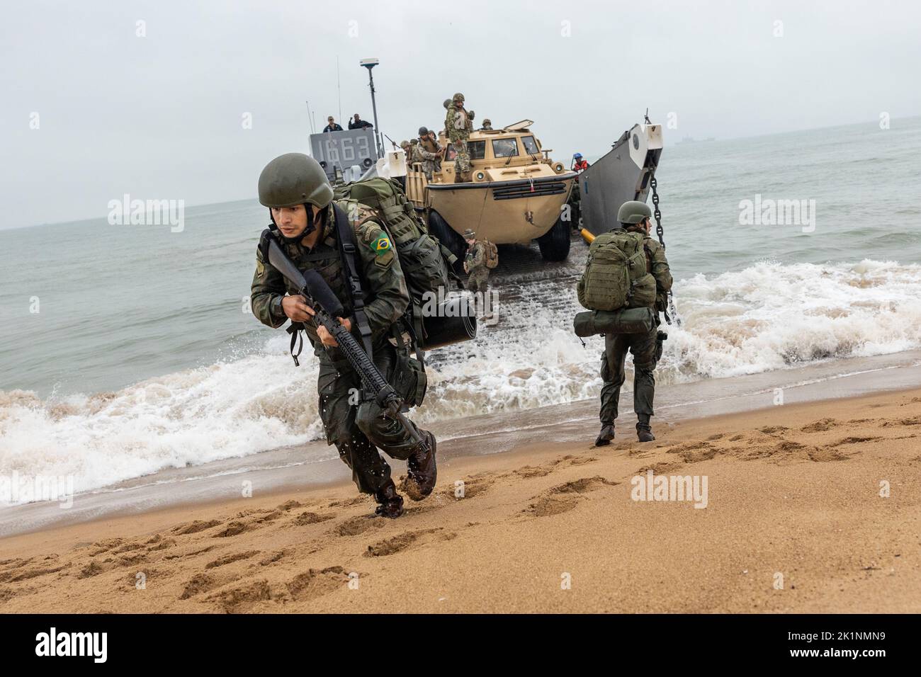A Brazilian marine runs ashore while executing an amphibious assault ...