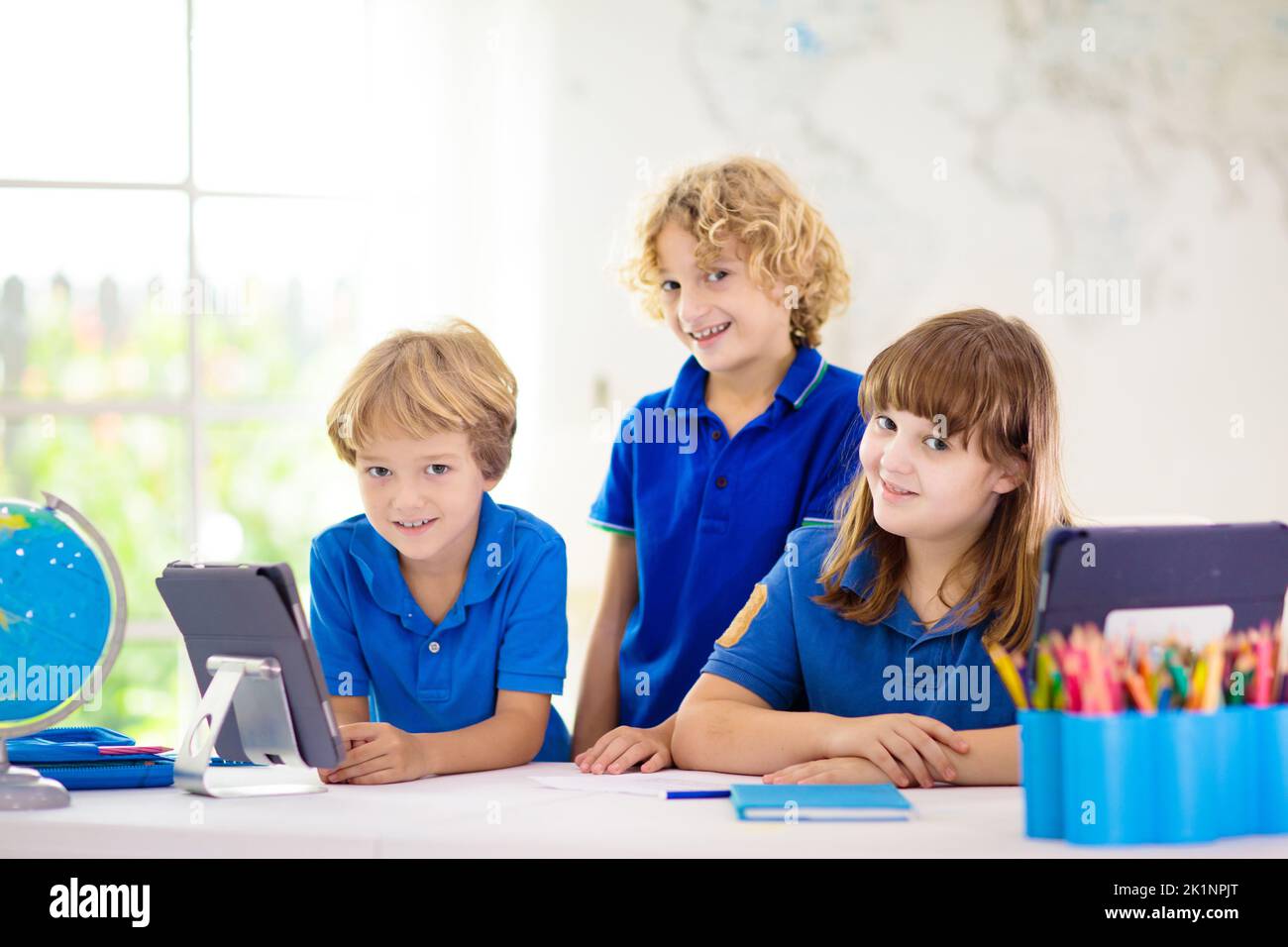 Online remote learning. School kids with computer having video ...