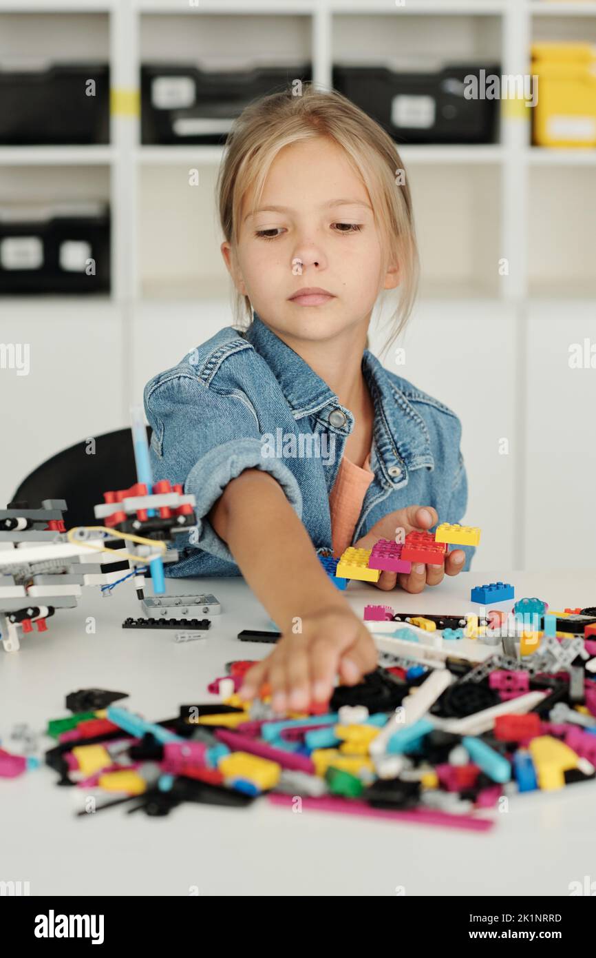Cute schoolgirl taking details of constructor while sitting by desk in ... Cute schoolgirl taking details of constructor while sitting by desk in ...