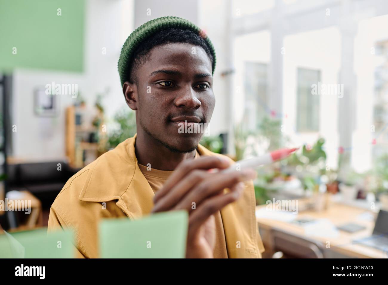 Young confident black man in casualwear pointing at transparent ...