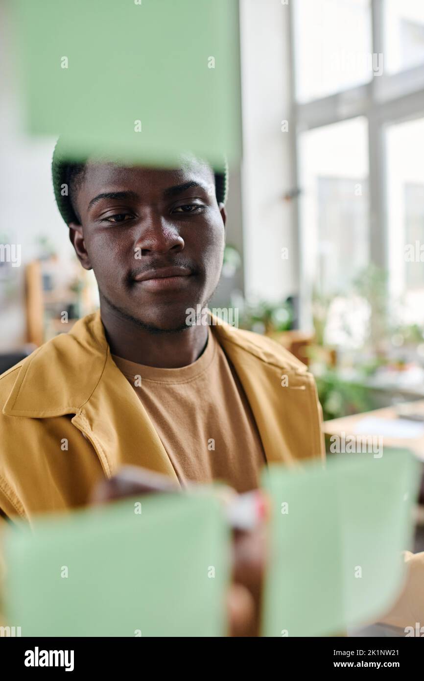 Young serious office manager standing in front of transparent ...