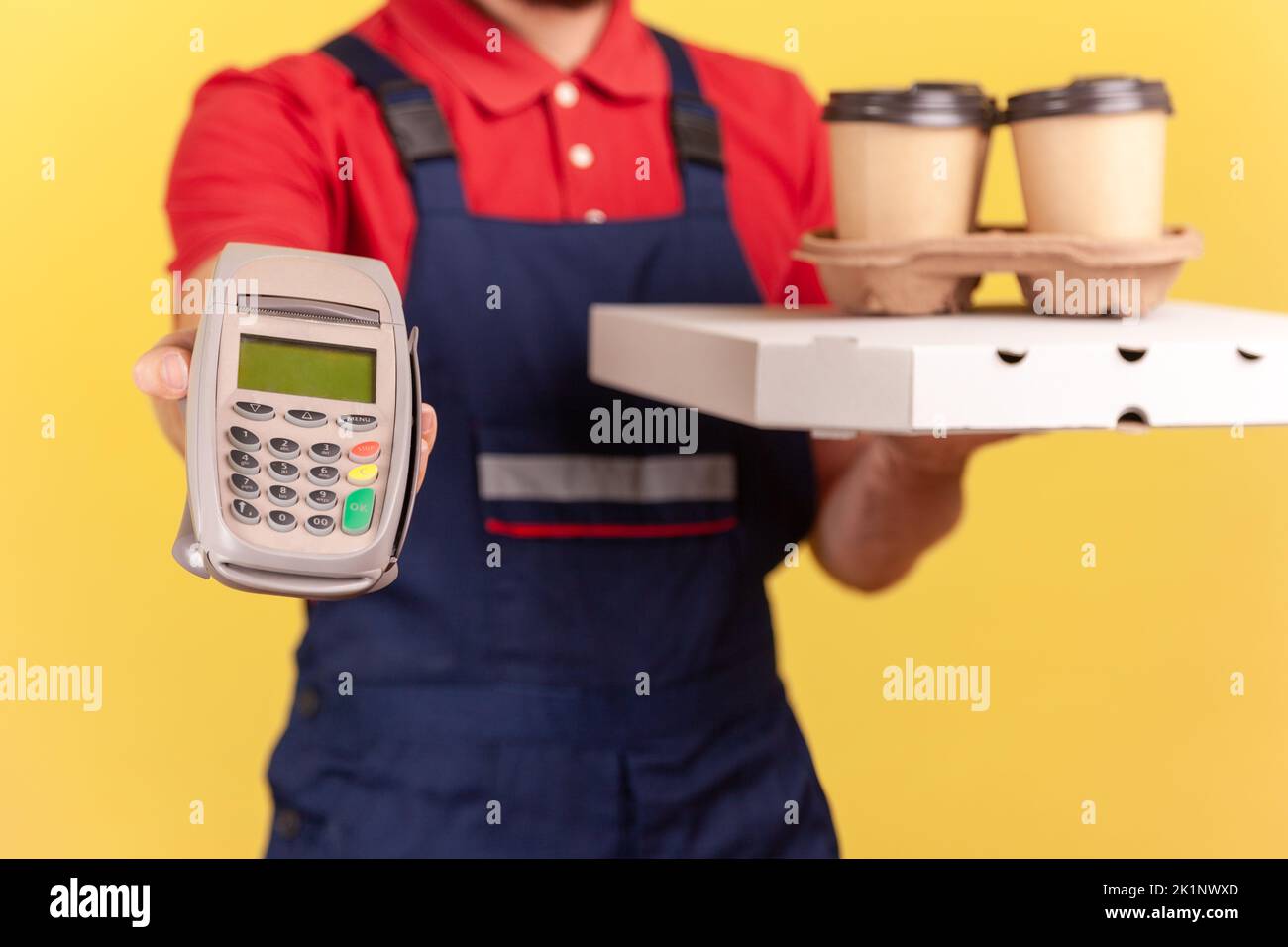 Anonymous delivery man standing with pizza box and coffee in disposable ...