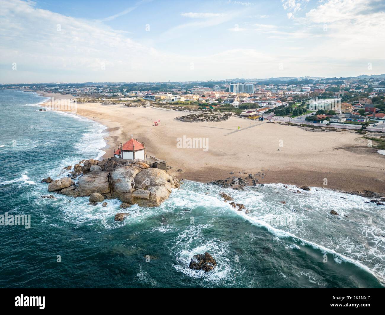 Aerial views of Senhor da Pedra Church, in the middle of the beach and ocean at Miramar ...
