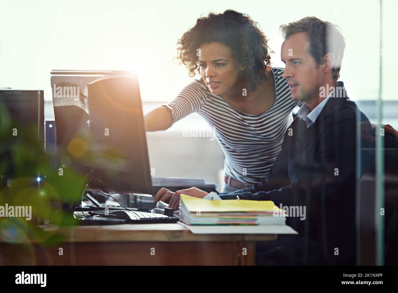 Whats that. two colleagues working together in the office Stock Photo ...