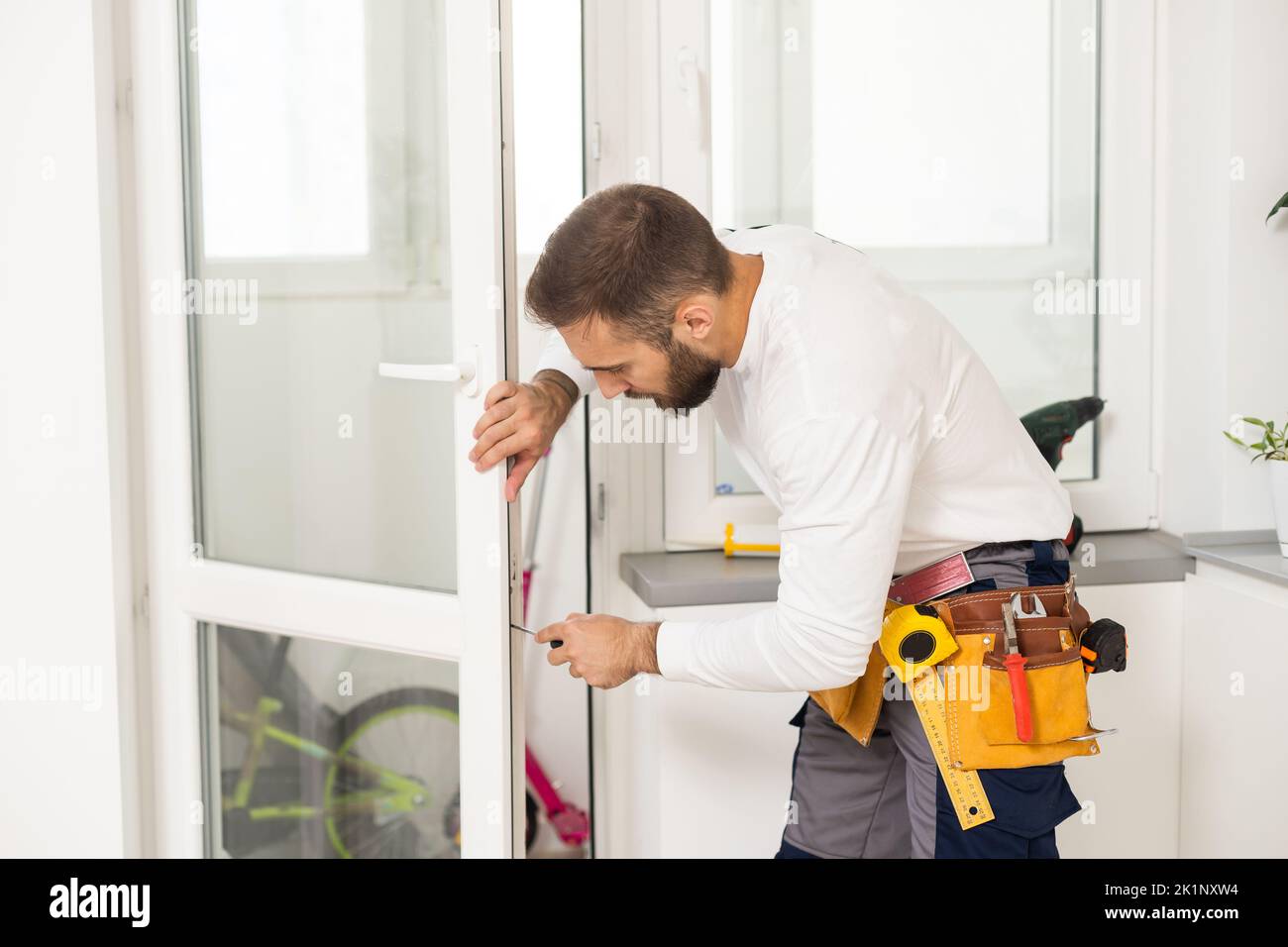service man installing window with screwdriver Stock Photo - Alamy