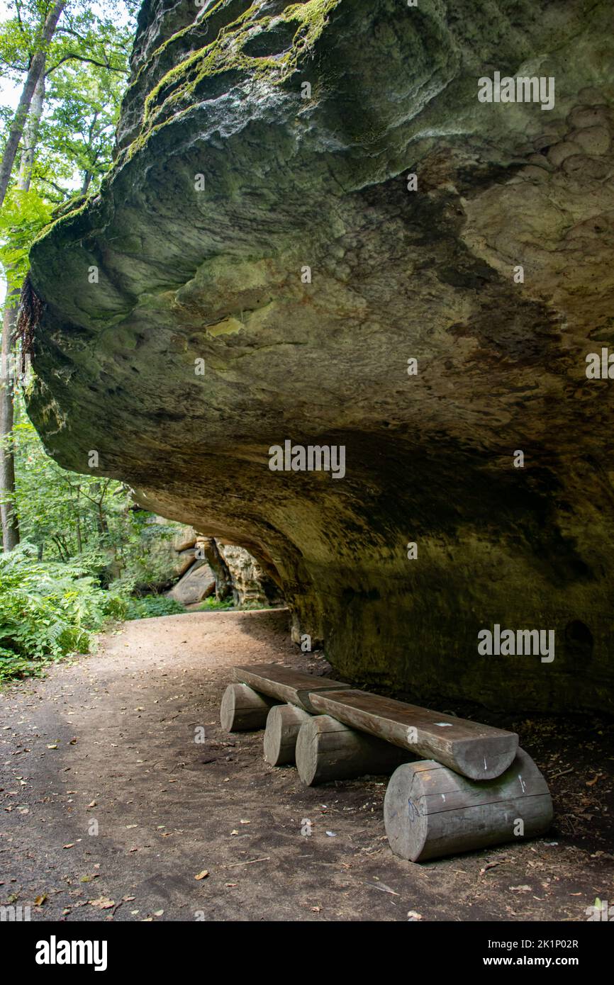Log benches on the rest area under the rock overhang Stock Photo - Alamy