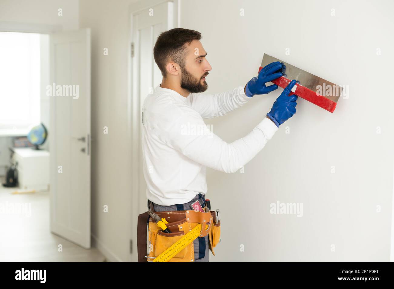 man plasterer construction worker at work, takes plaster from bucket ...