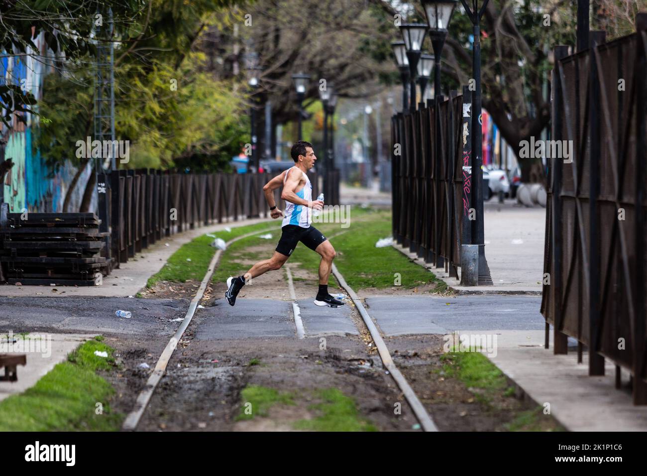 An elite runner crosses some railway tracks in the Buenos Aires ...