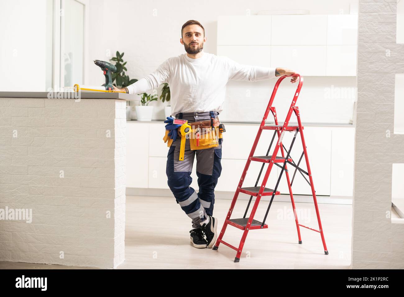 Professional worker climbing up ladder in room Stock Photo - Alamy