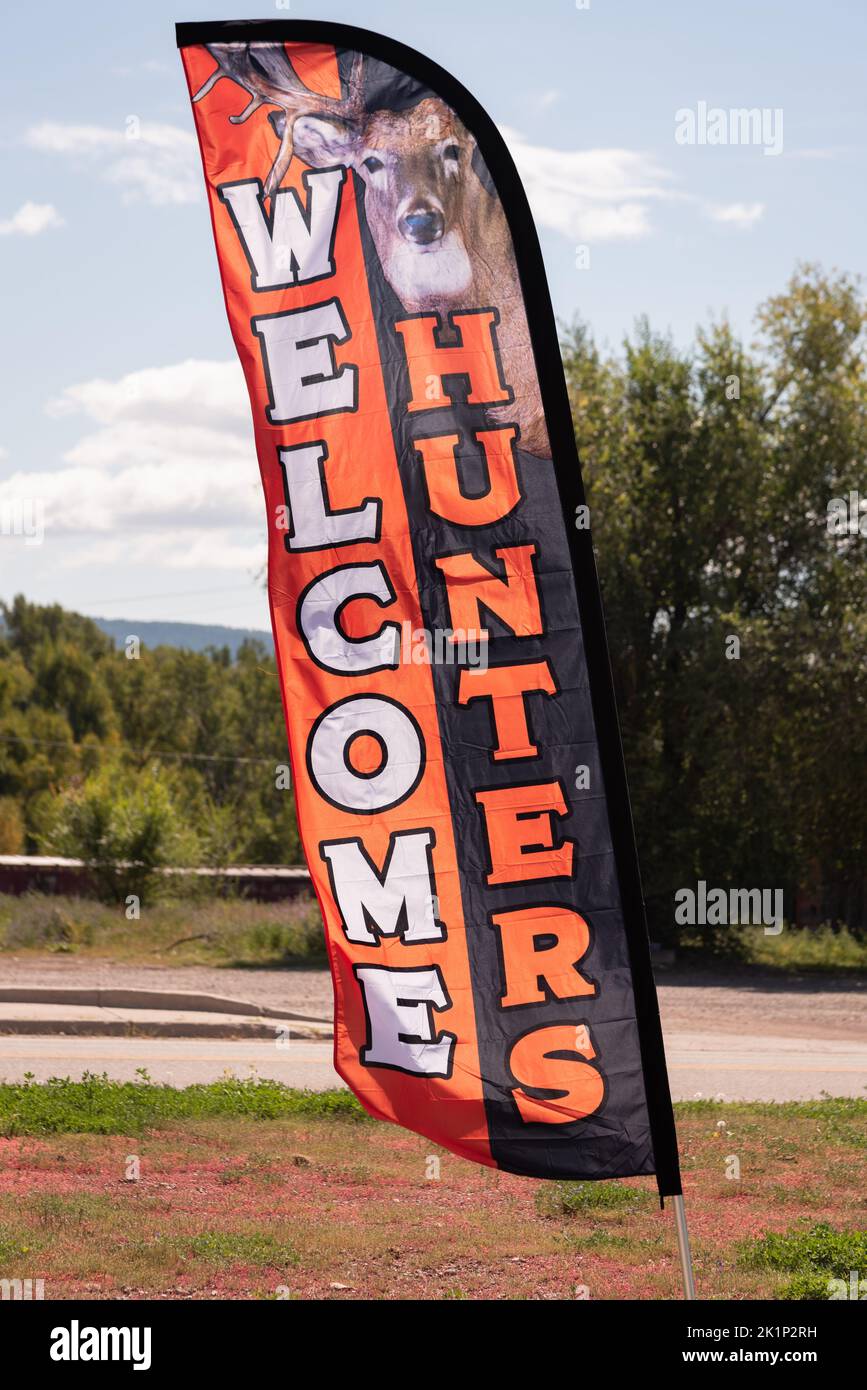 Orange and black feather flag with a picture of a deer reads Welcome ...