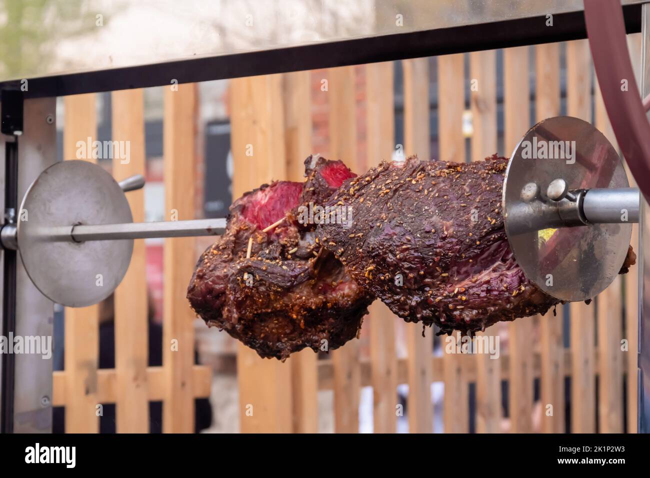 Process of cooking large meat peaces on spit over open fire Stock Photo ...
