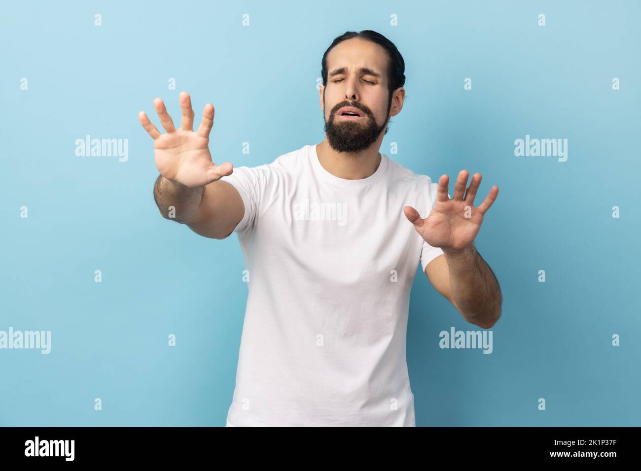 Portrait of disoriented blind man with beard wearing white T-shirt ...