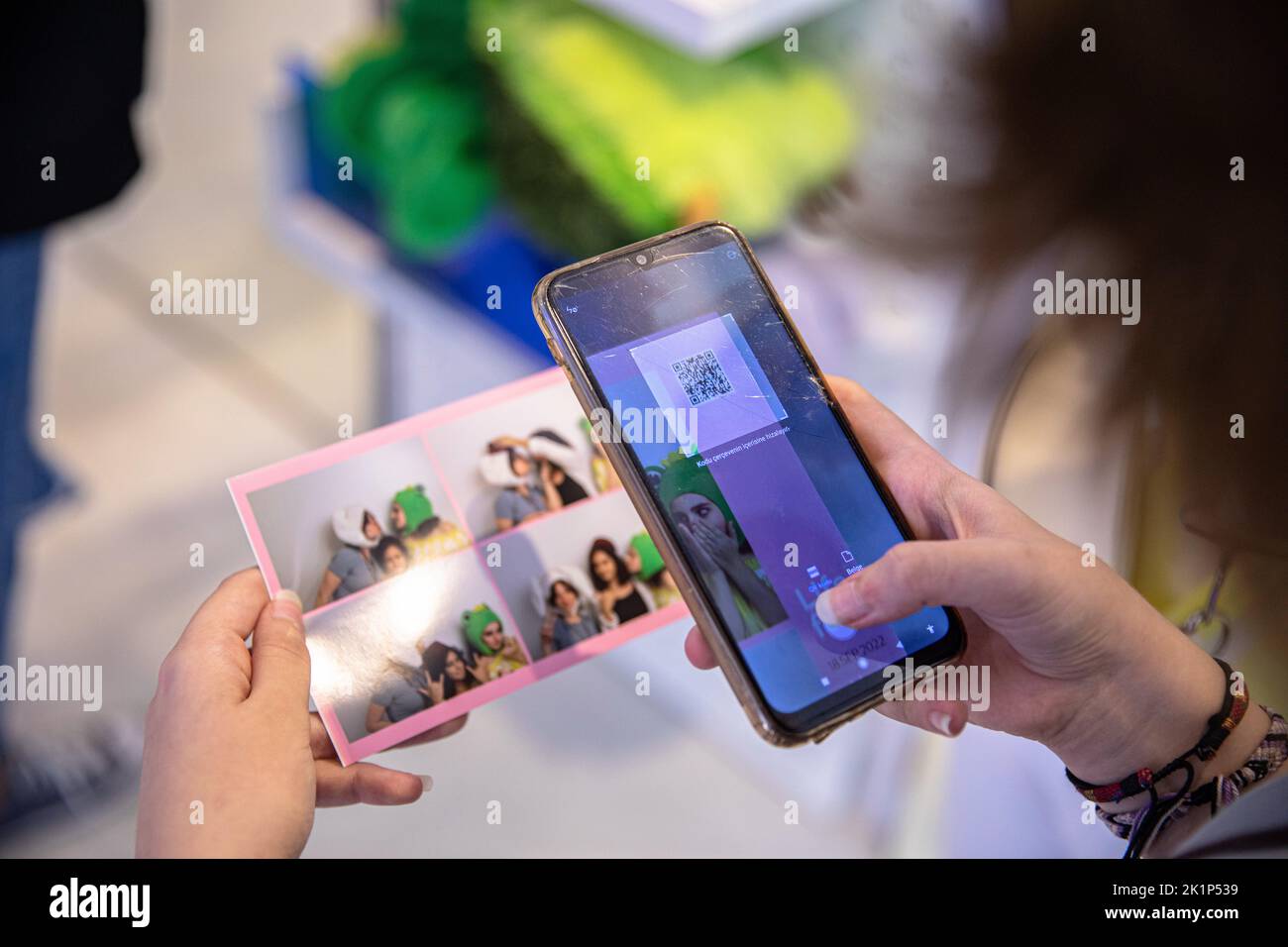 Customer seen reading the QR code on the photo print after shooting ...