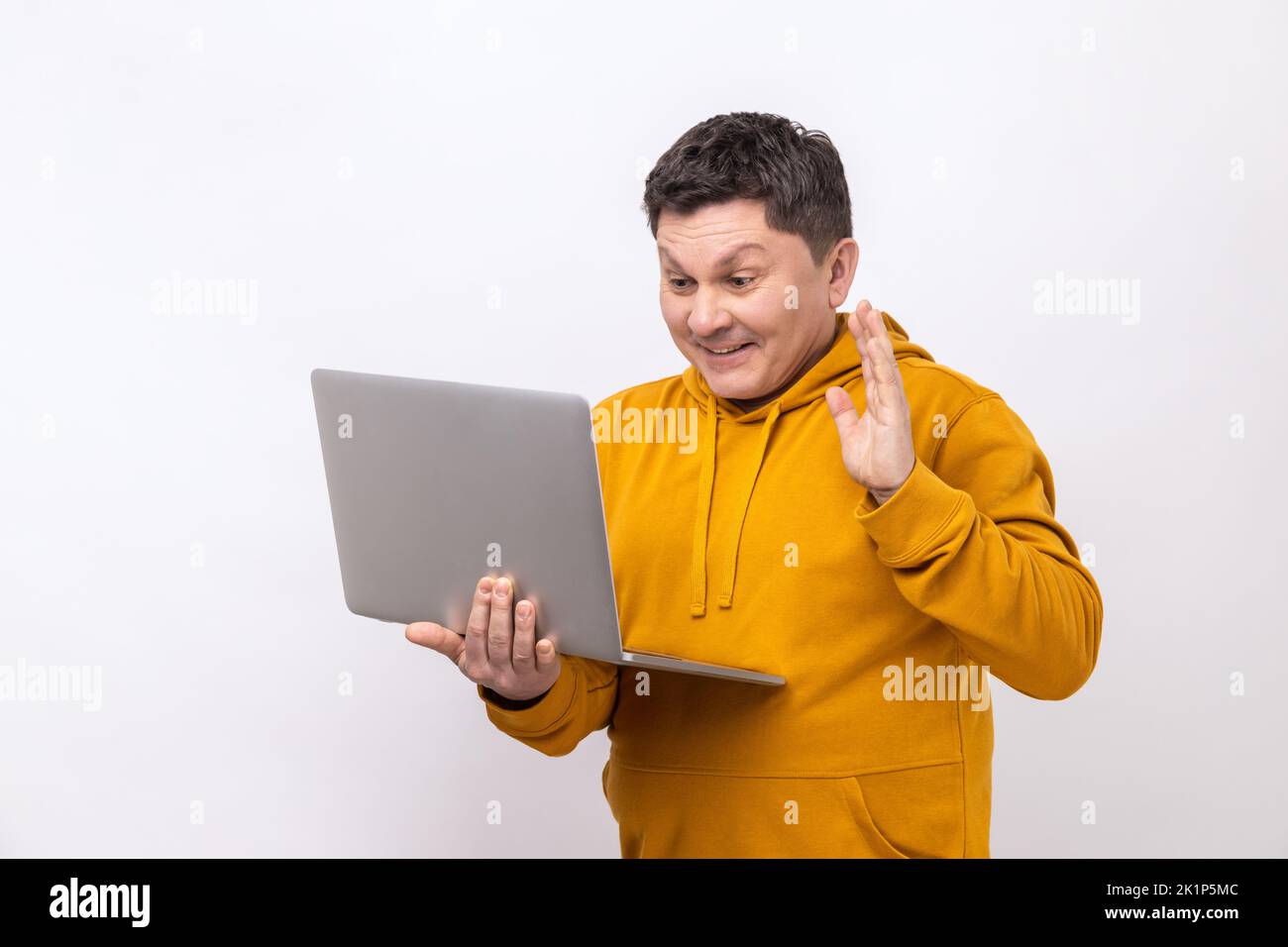 Man waving hand gesturing hello to laptop screen, talking on video call ...