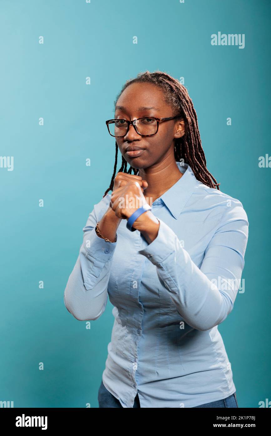 Serious and brave woman getting in ready position for boxing while ...