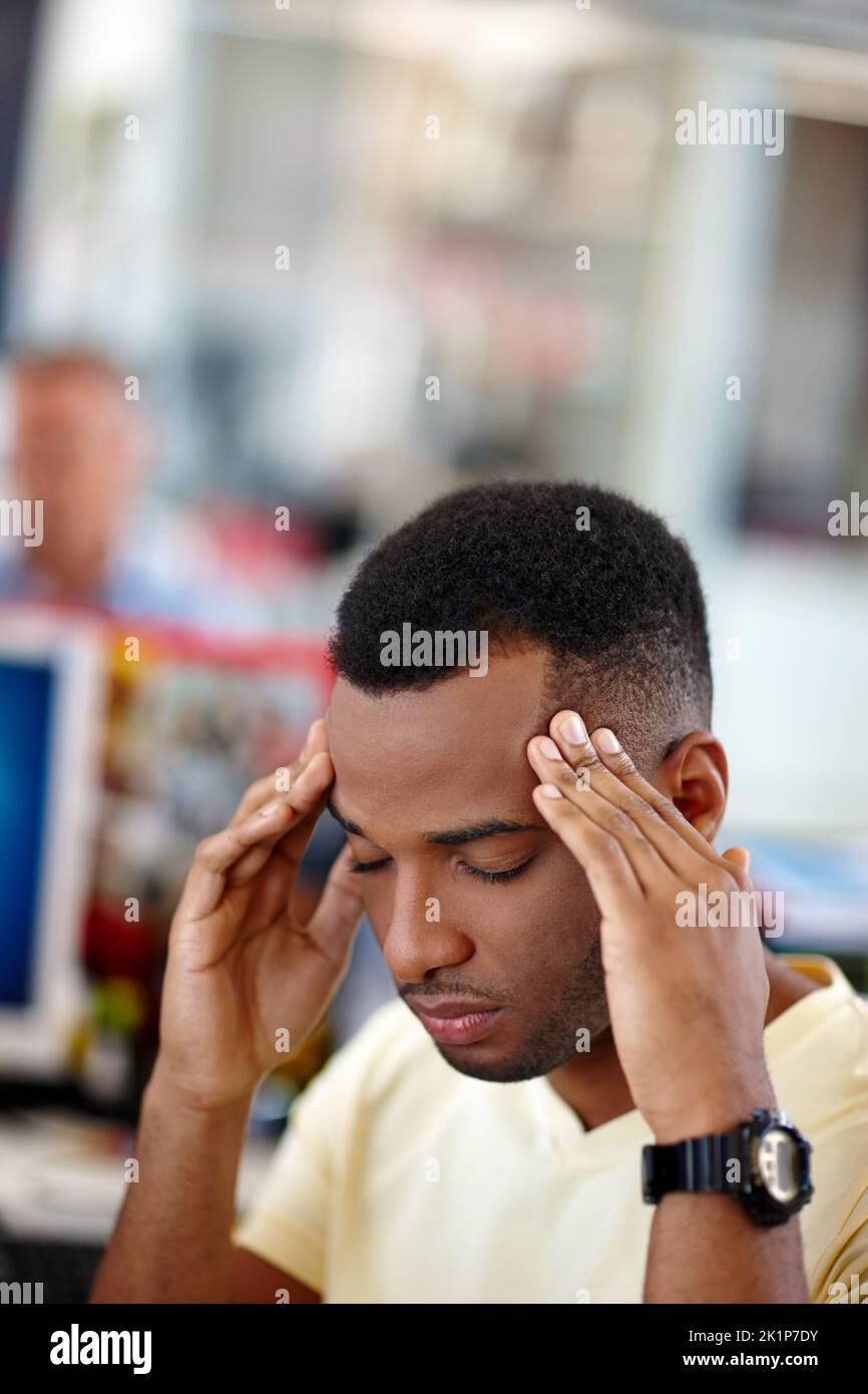 I think too much. a handsome young man suffering from a headache at ...