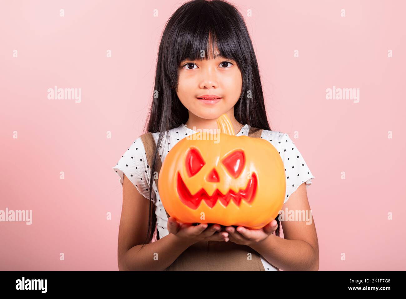 Asian little kid 10 years old holding carved Halloween pumpkin at ...