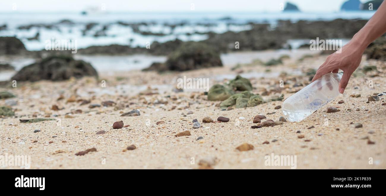 Volunteer hand pick up trash, plastic Bottle garbage on the beach ...