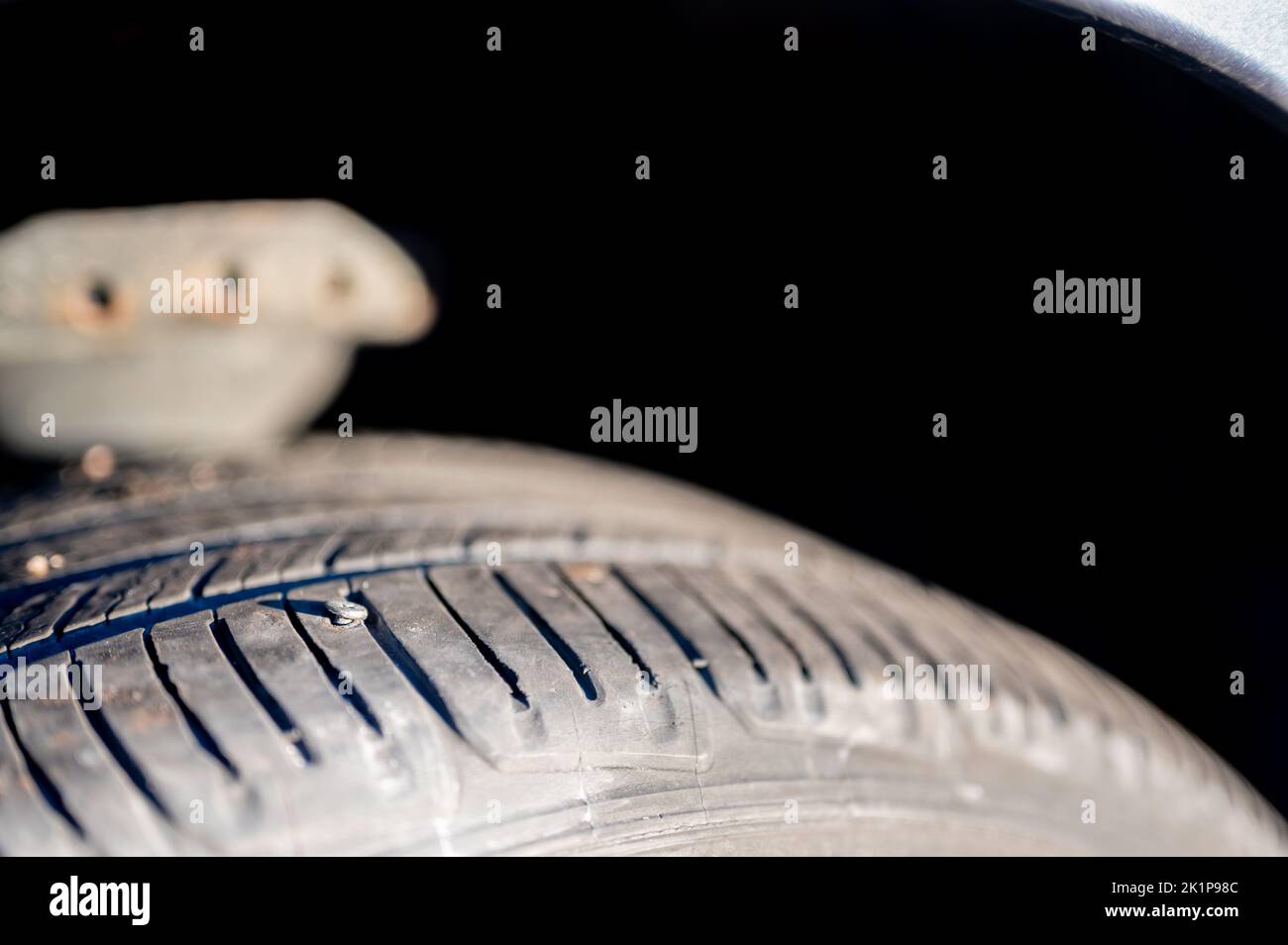 screw protruding from the tread of a tire causing a flat Stock Photo ...