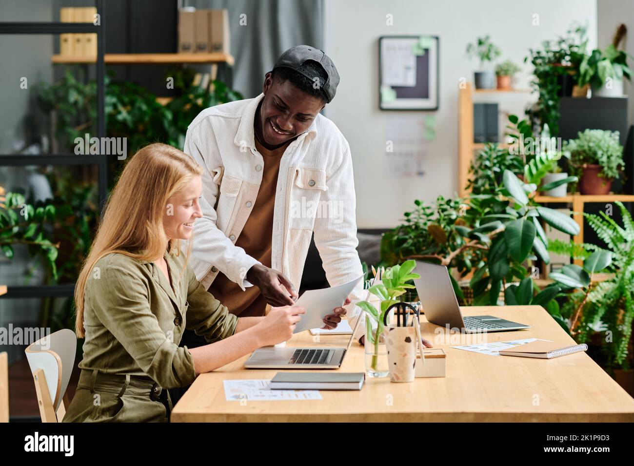 Happy young successful colleagues discussing financial data in front of ...