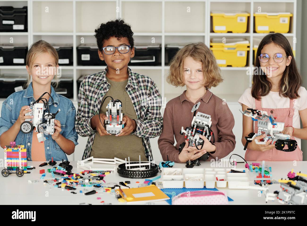Group of happy youthful intercultural elementary schoolkids holding ...