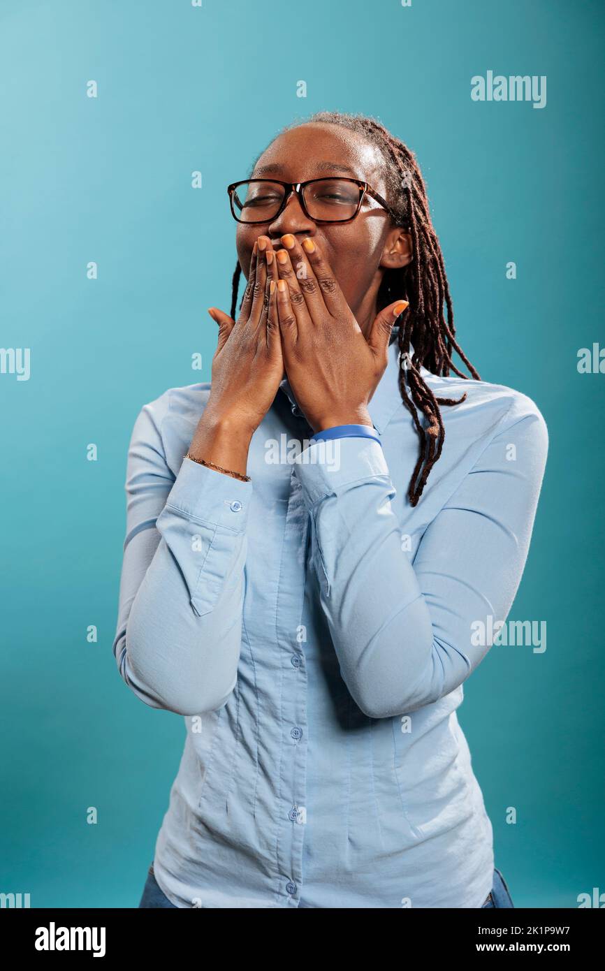 Exhausted african american person catching a yawn while putting hand ...