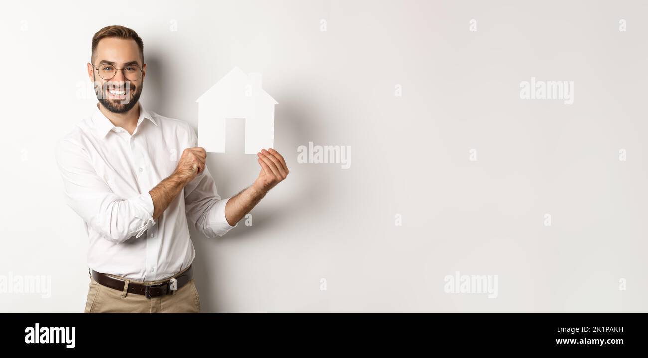 Real estate. Handsome man showing house model and smiling, broker ...
