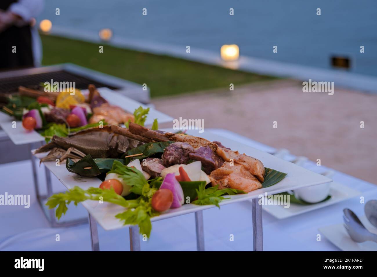 Luxury dinner table by the ocean with lobster, fish, and Thai food ...