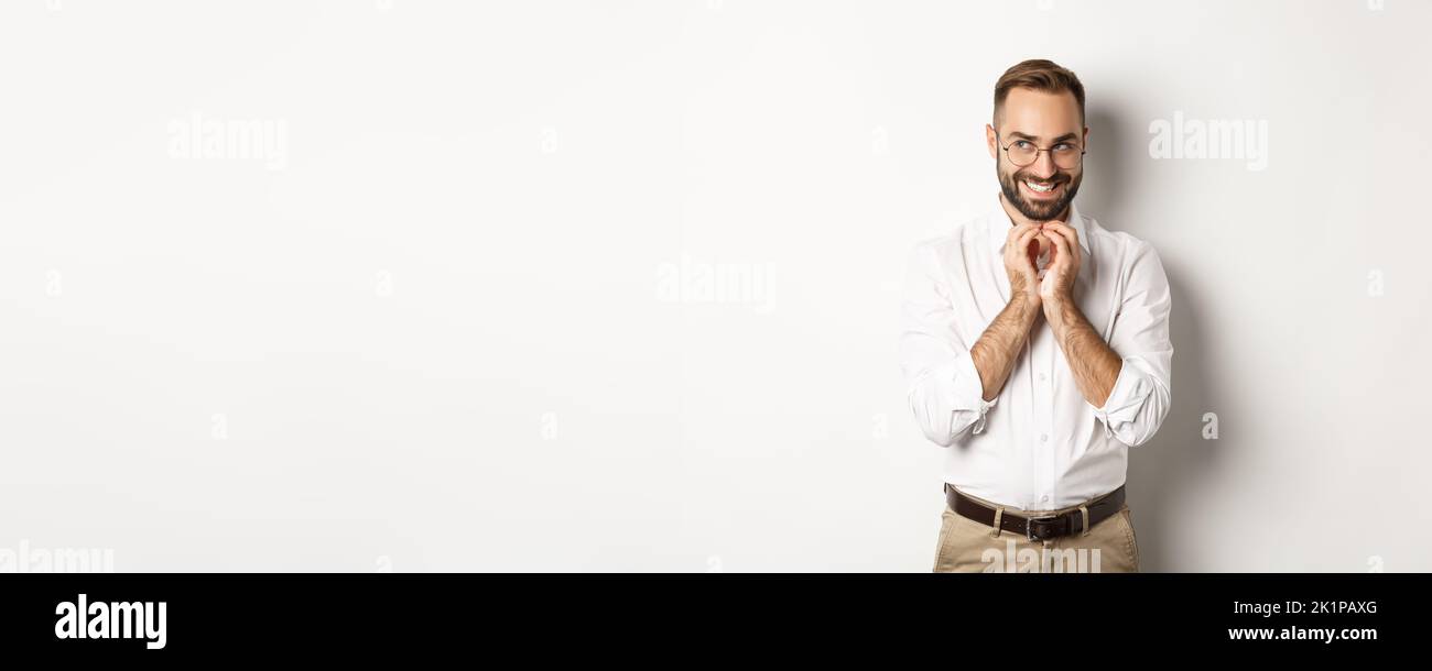 Young cunning businessman steeple fingers and smiling devious, scheming ...