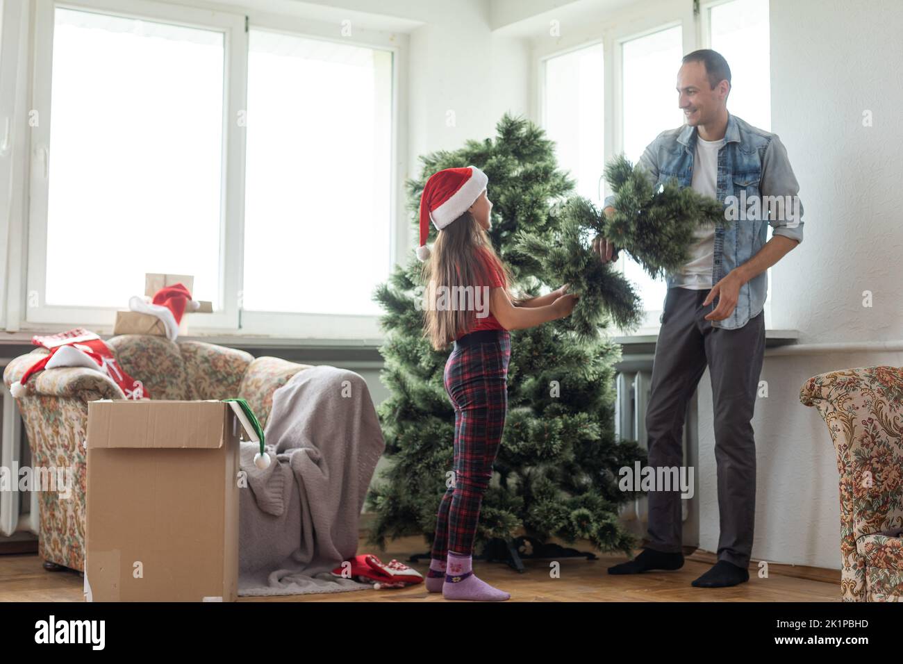 father and daughter install an artificial Christmas tree Stock Photo ...