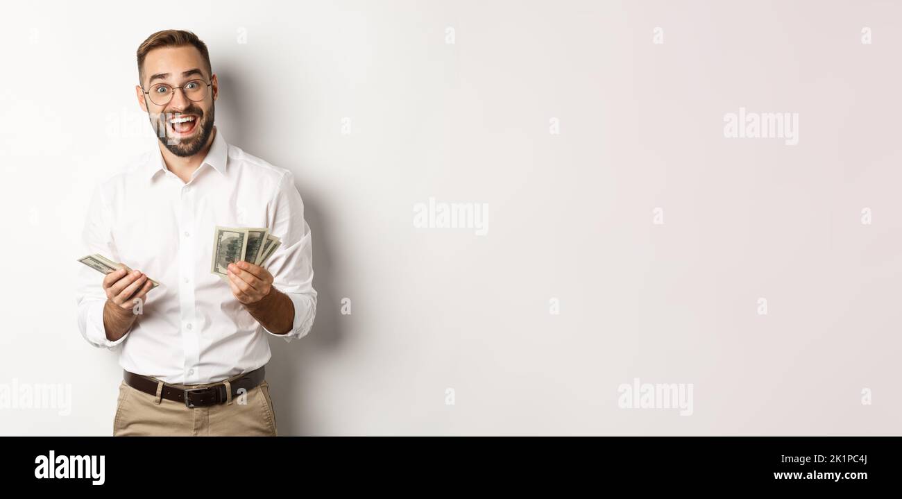 Handsome business man looking excited while counting money, standing ...