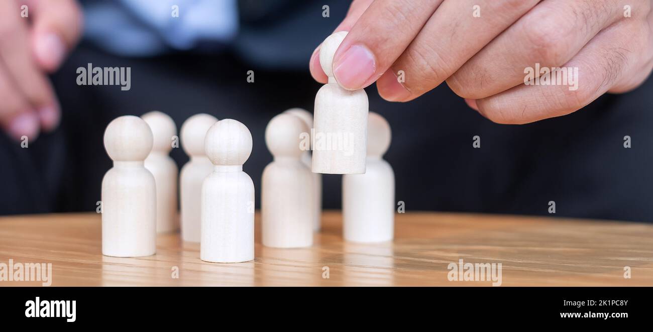Businessman hand pulling leader man wooden from crowd of employees ...