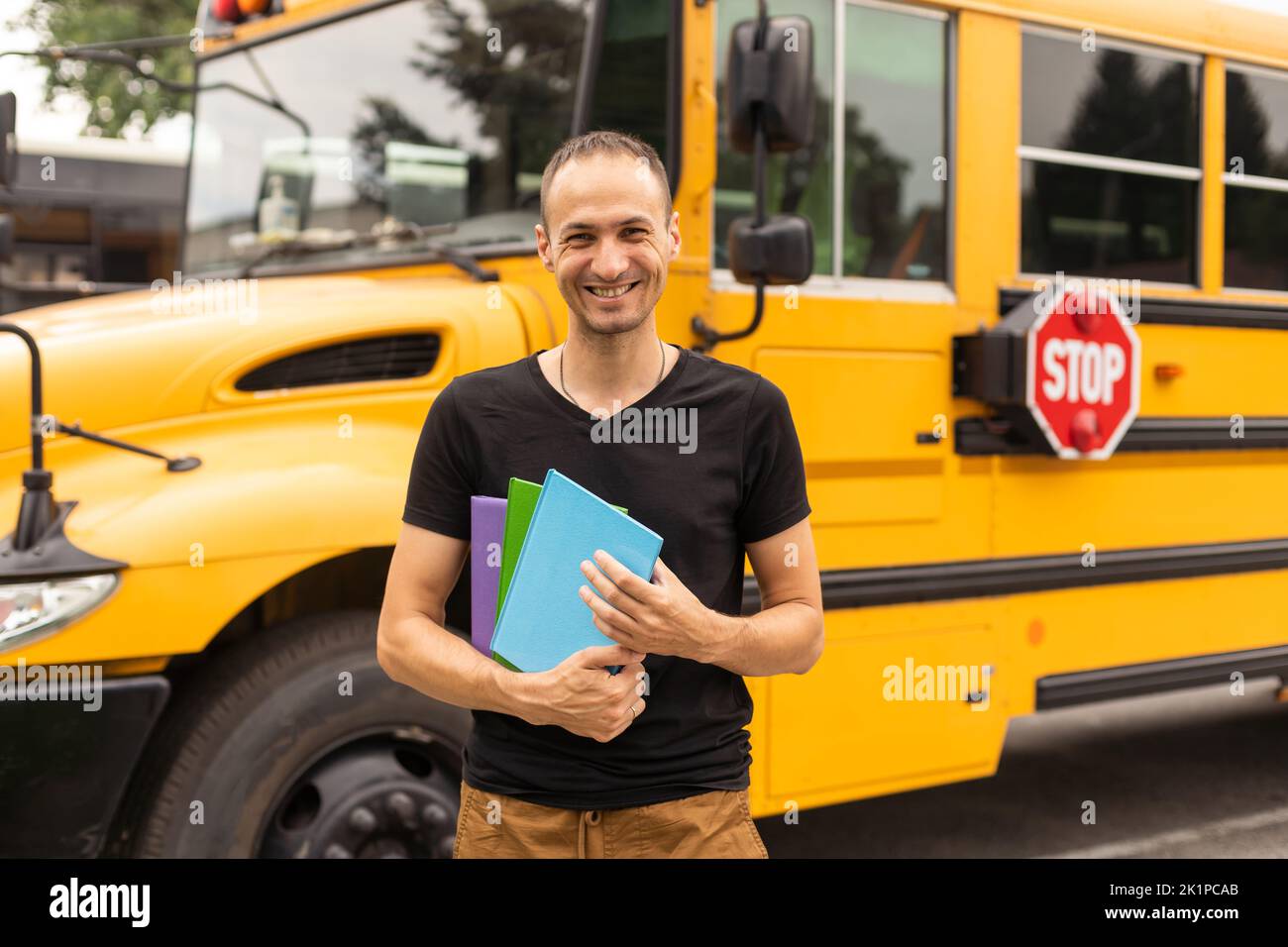 male teacher near school bus Stock Photo - Alamy