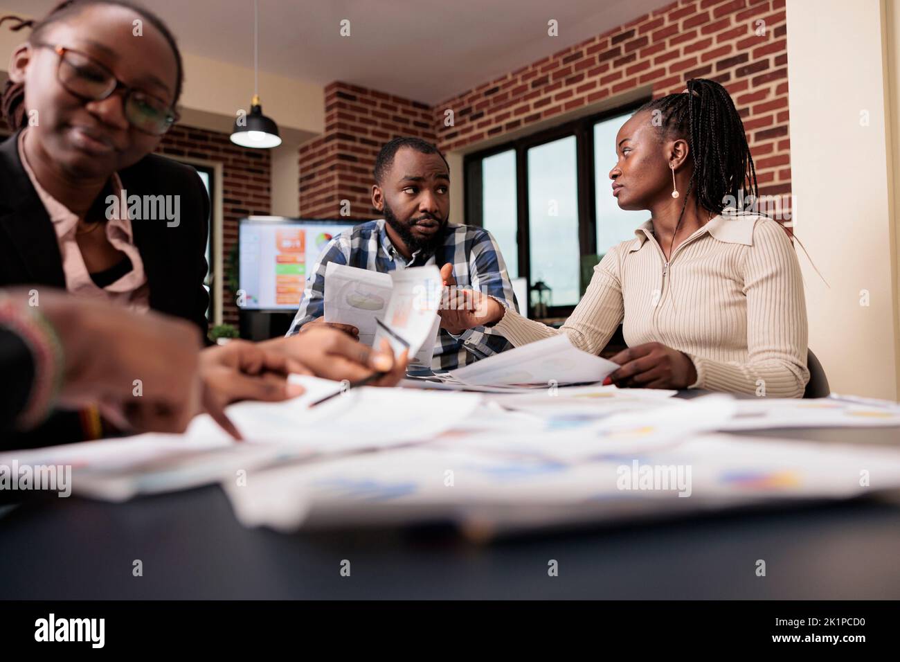 Team of colleagues analyzing documents in office, doing teamwork collaboration to create ...