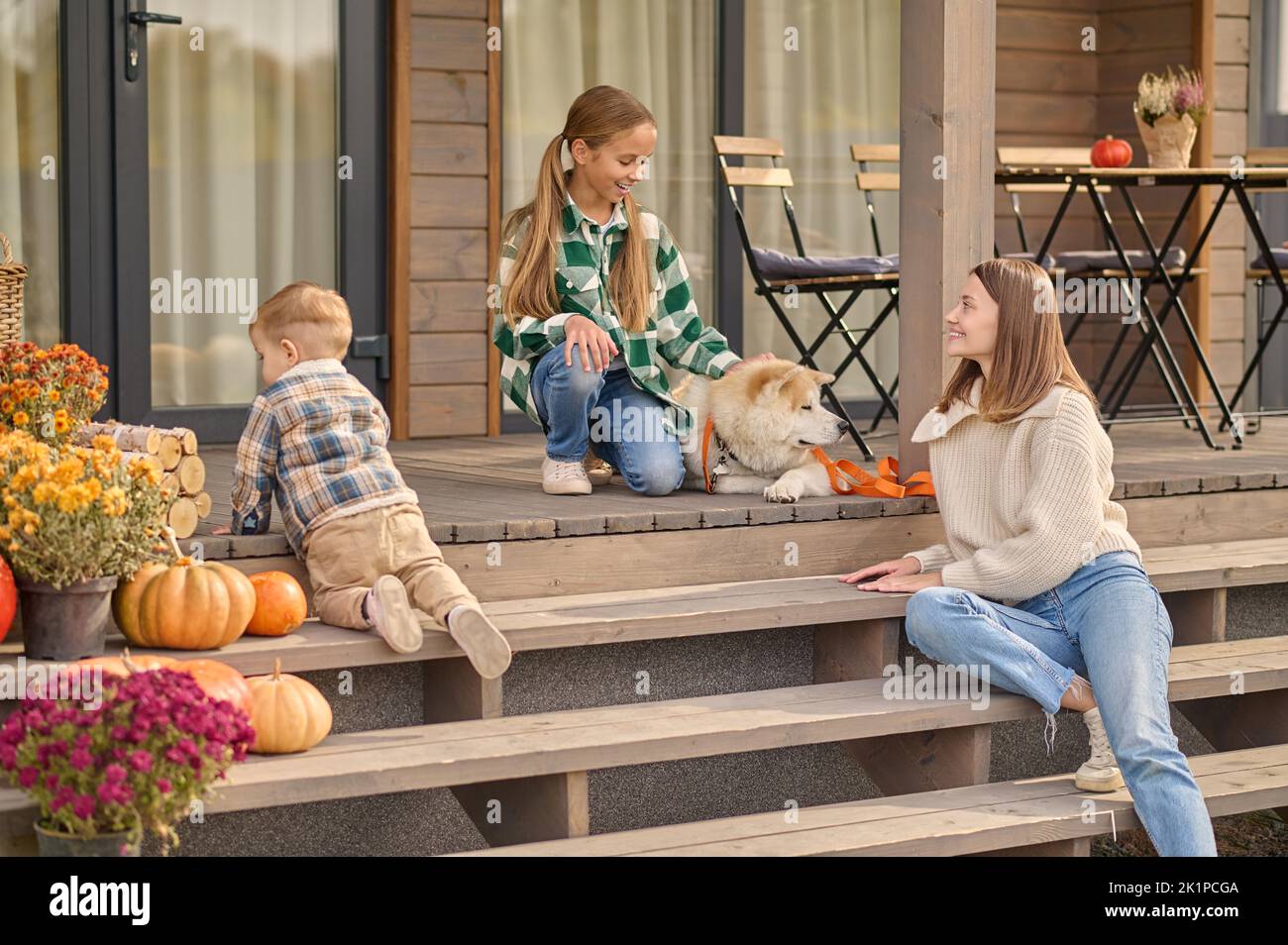 Female parent spending time with her kids on the veranda Stock Photo ...