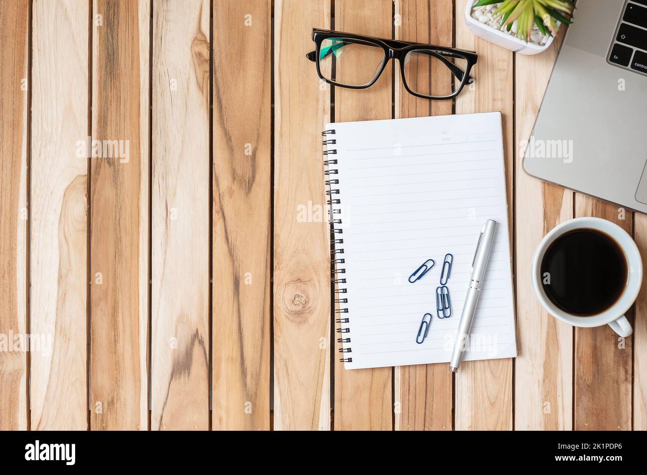 Top view Office desk with blank notebook, pen, paper clips, computer ...