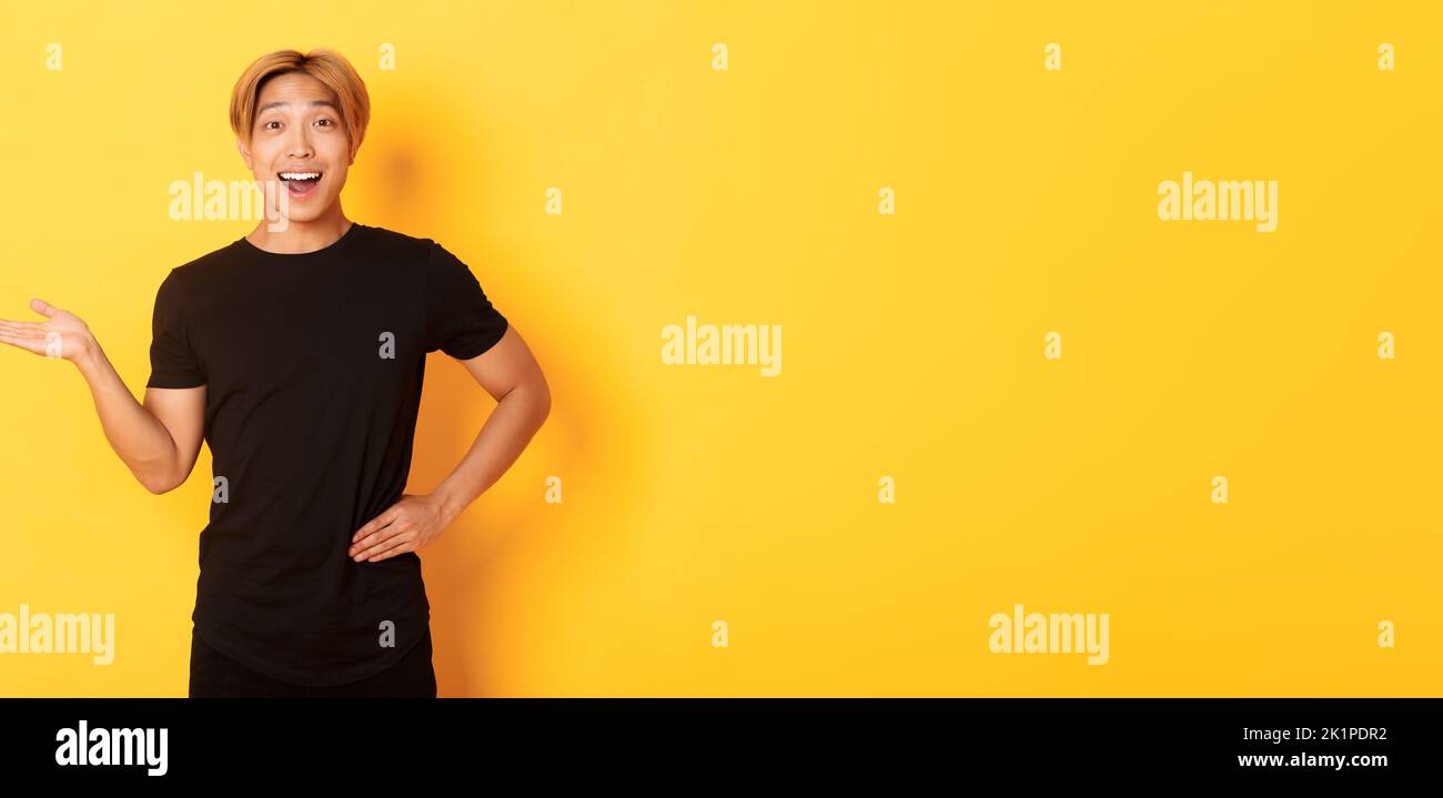 Portrait of happy and excited smiling asian guy holding something on ...