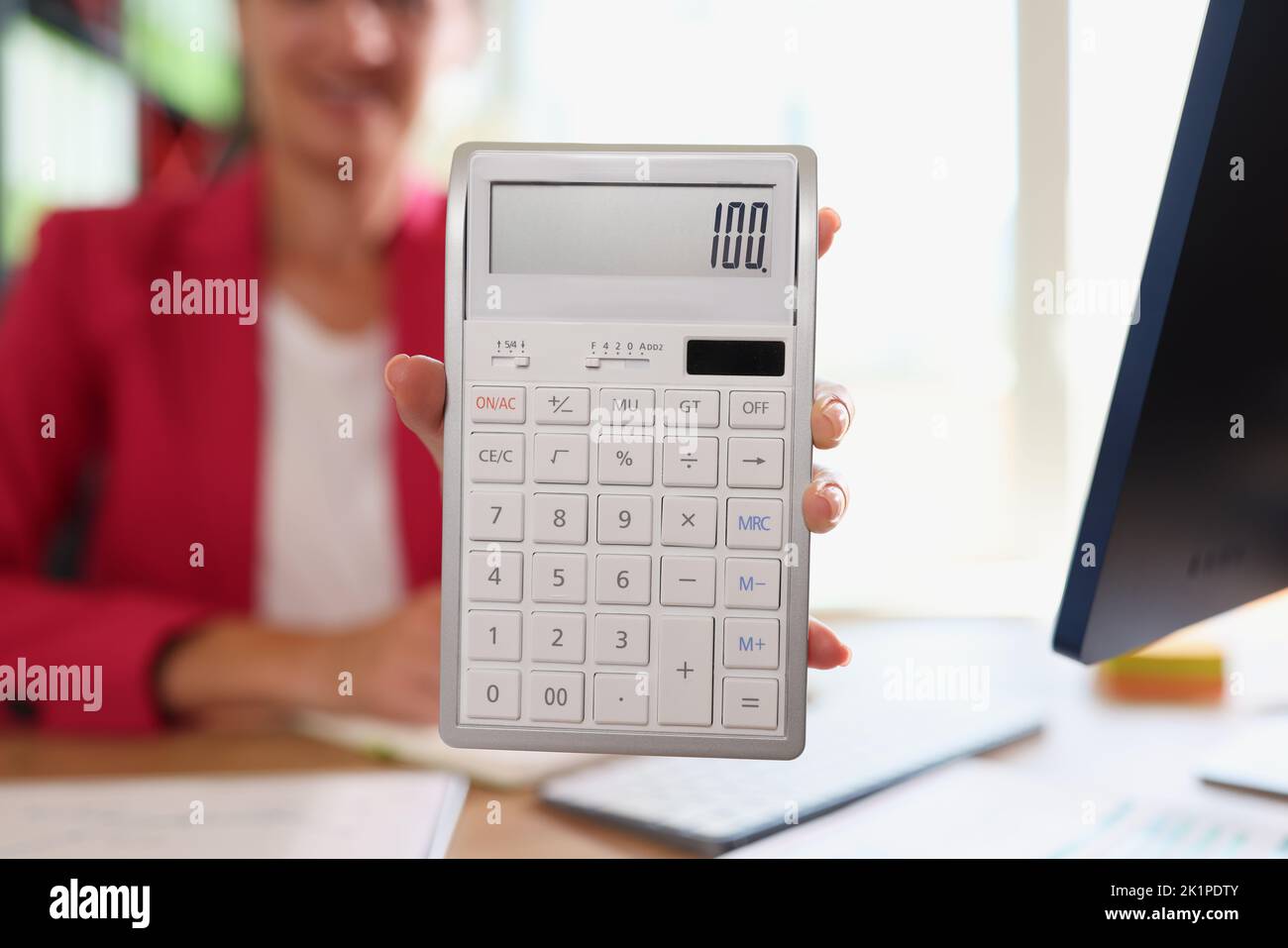 Woman accountant is holding calculator with number one hundred Stock ...